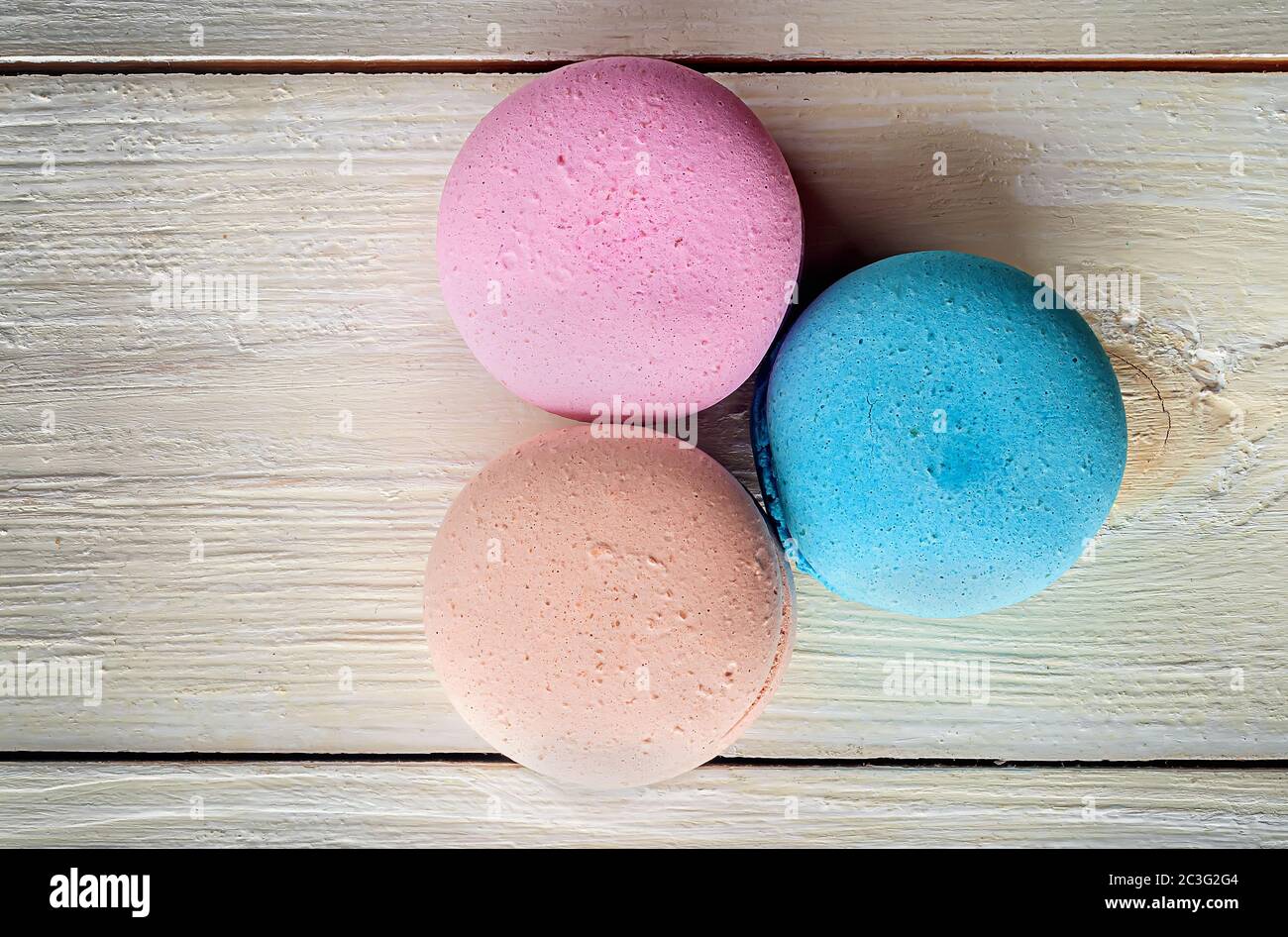 Three macaroons near in white desk Stock Photo - Alamy