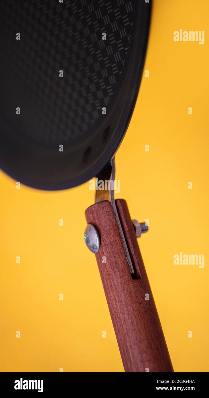 Homemade wooden handle, part of flat metallic pancake pan on yellow ...