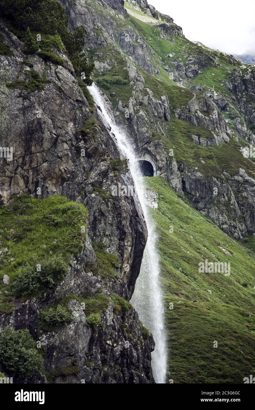 Vertical shot of a waterfall with a road tunnel in a mountain Stock ...