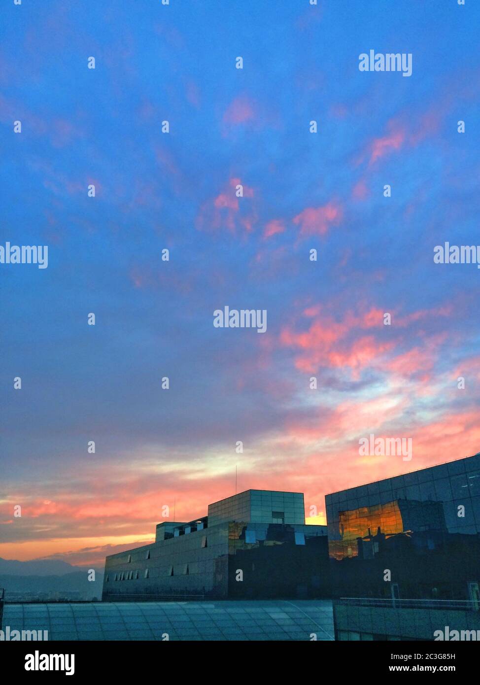 Vertical shot of a beautiful sunset sky over high-rise buildings Stock ...