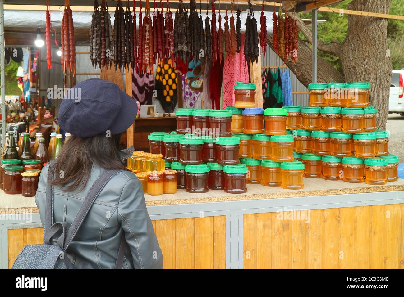 Female traveler in front of a souvenir stand with local products of ...