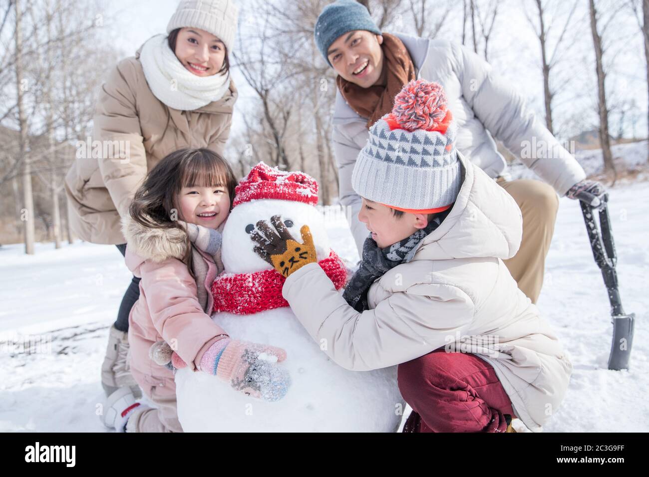 Family with snowman hi-res stock photography and images - Alamy