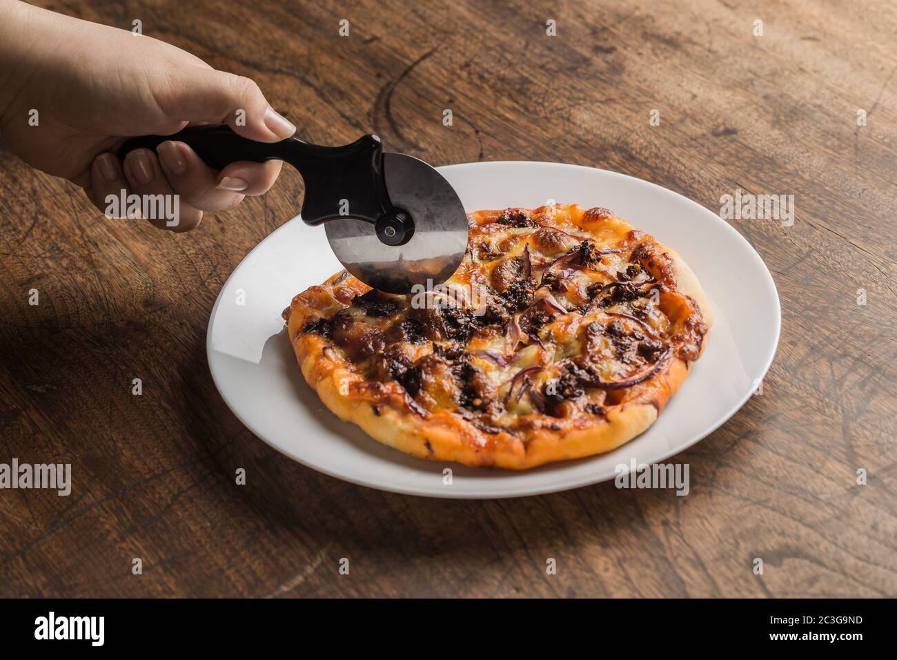Chef cuts freshly prepared pizza slices Stock Photo - Alamy