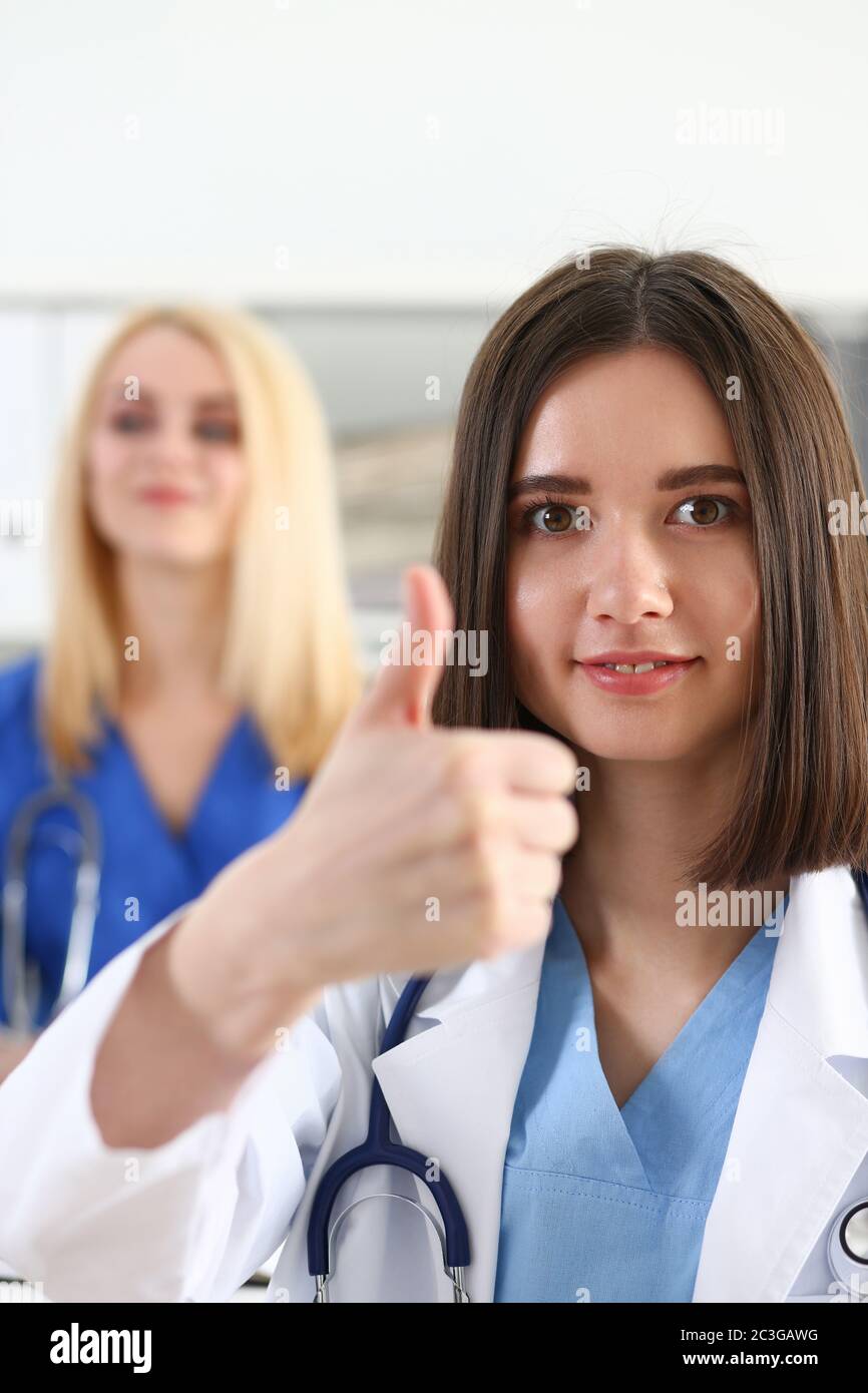 Beautiful smiling female doctor showing OK Stock Photo - Alamy