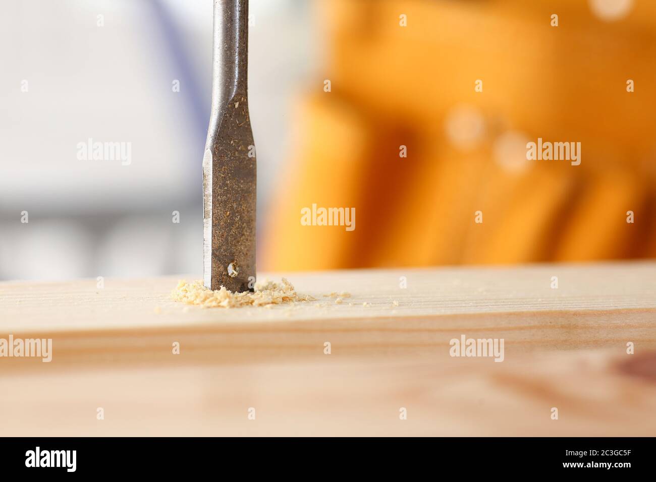 Flat drill bit make hole in wooden bar closeup Stock Photo - Alamy