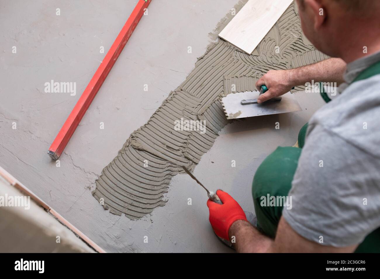 Professional construction worker laying ceramic tiles on the floor in ...