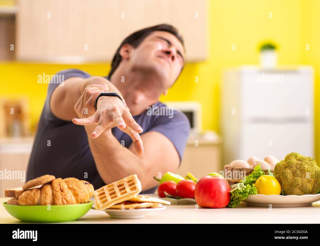 Man having hard choice between healthy and unhealthy food Stock Photo ...