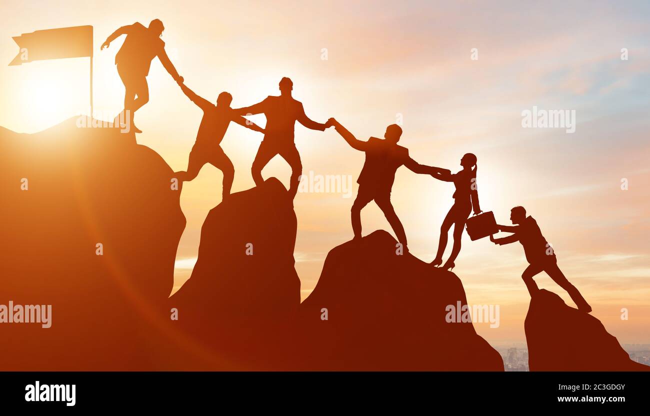 Concept of teamwork with team climbing mountain top Stock Photo - Alamy