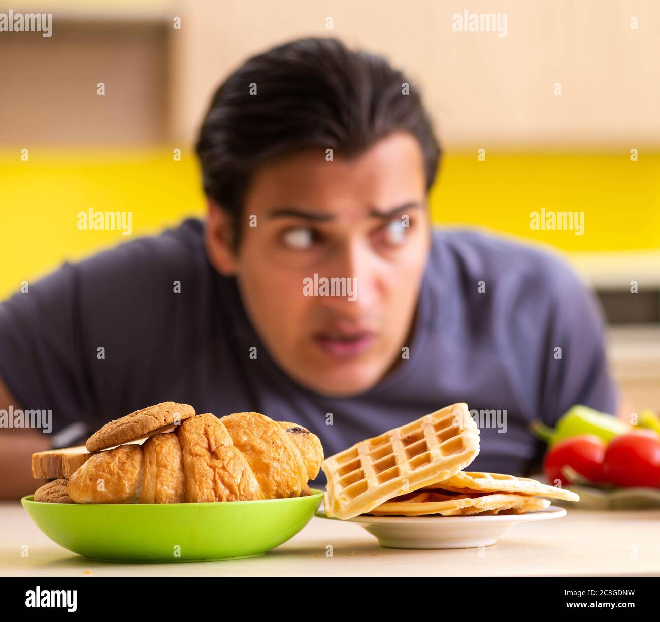 Man having hard choice between healthy and unhealthy food Stock Photo ...