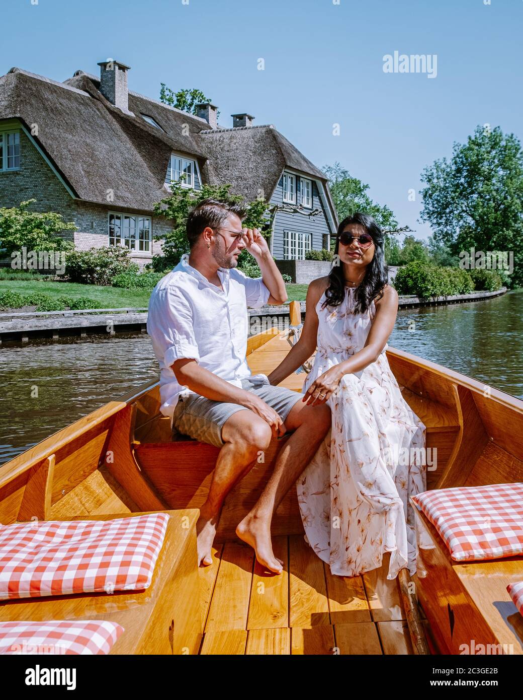 Giethoorn Netherlands couple visit the village with a boat ,view of famous village with canals ...