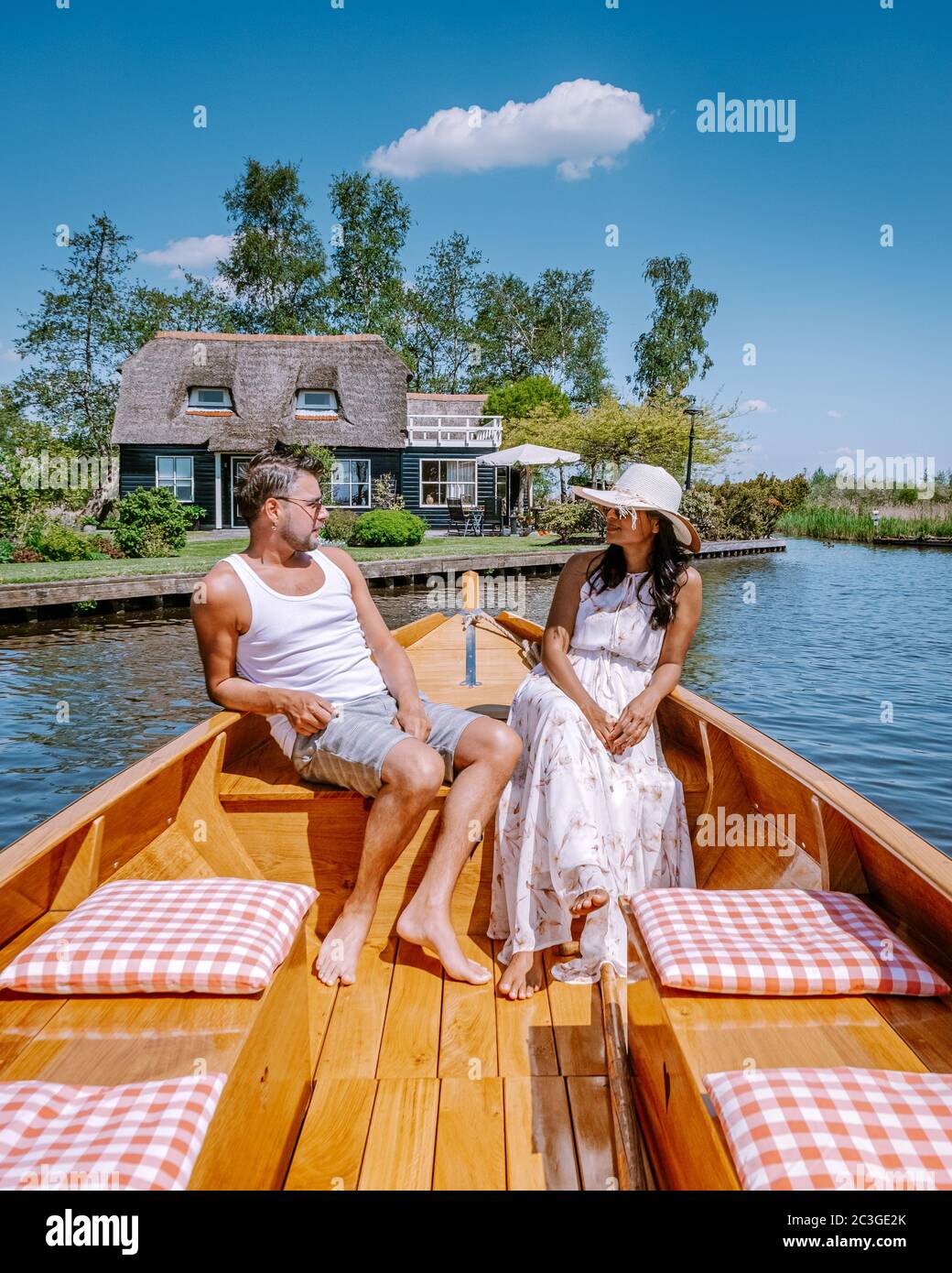 Giethoorn Netherlands couple visit the village with a boat ,view of famous village with canals ...
