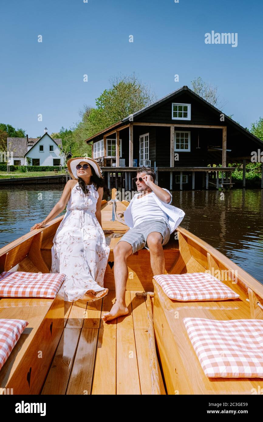 Giethoorn Netherlands couple visit the village with a boat ,view of famous village with canals ...