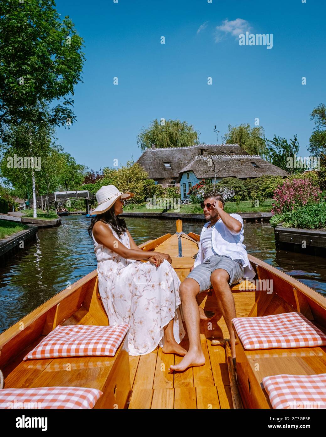Giethoorn Netherlands couple visit the village with a boat ,view of famous village with canals ...