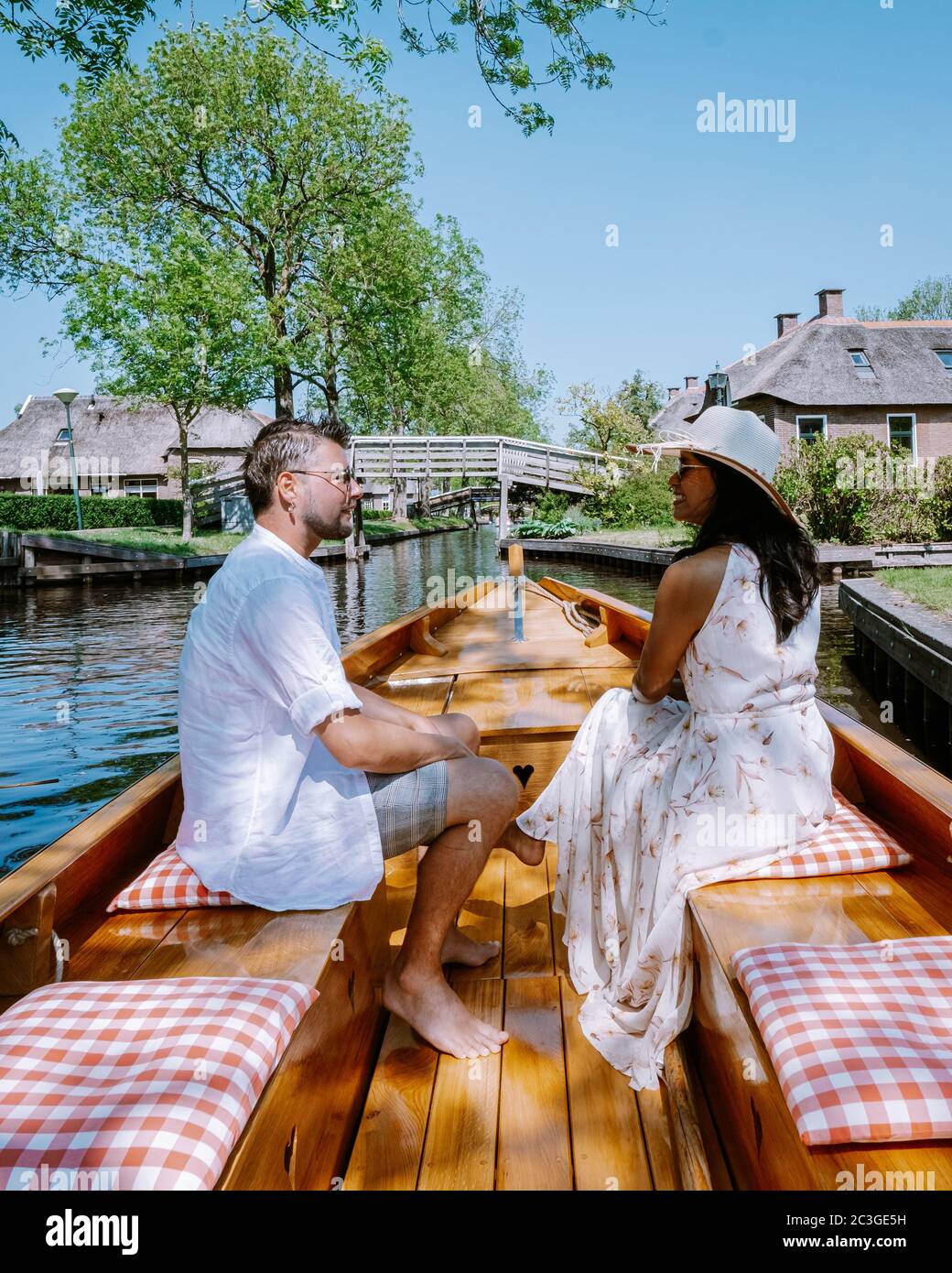 Giethoorn Netherlands couple visit the village with a boat ,view of famous village with canals ...