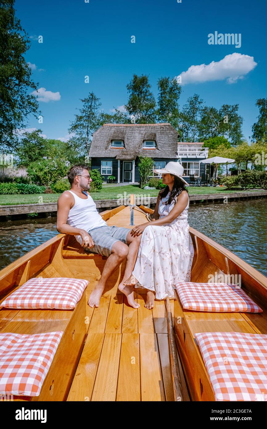 Giethoorn Netherlands couple visit the village with a boat ,view of famous village with canals ...