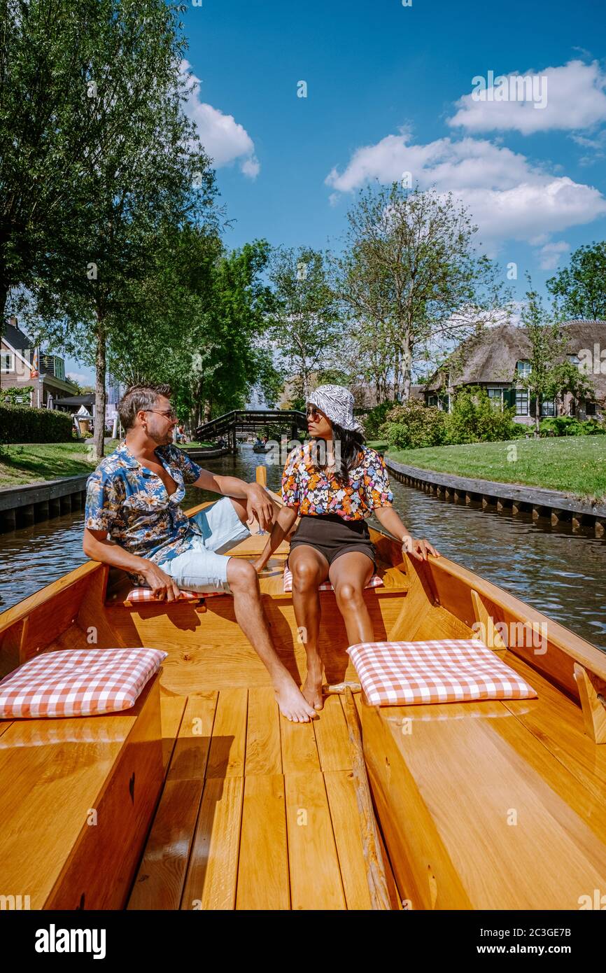 Giethoorn Netherlands couple visit the village with a boat ,view of famous village with canals ...