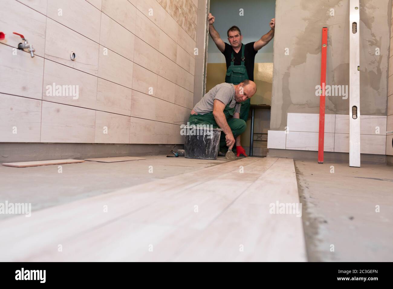 Professional construction worker laying ceramic tiles on the floor in ...