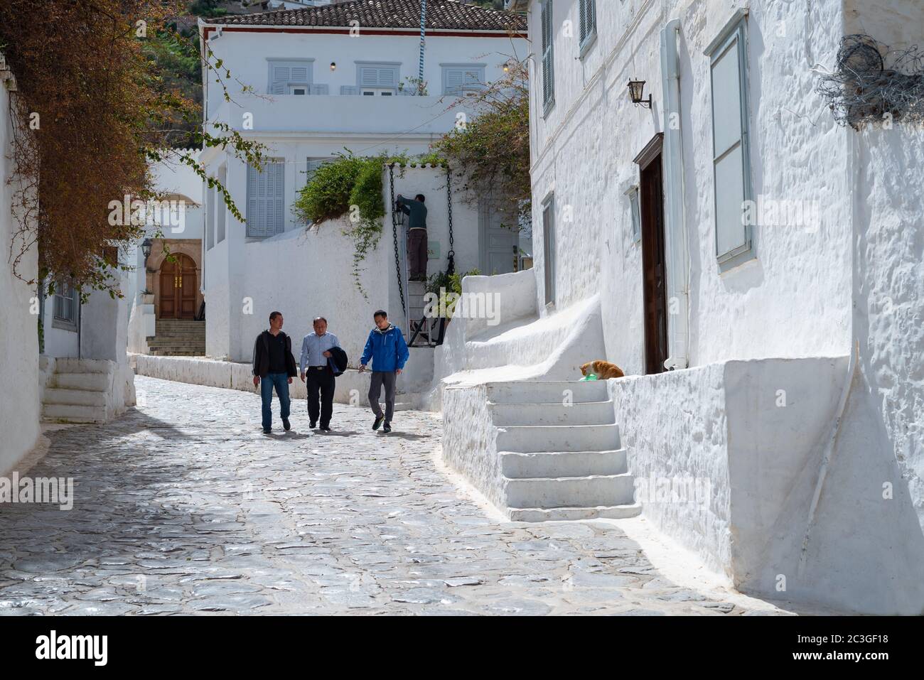 Hydra, Greece - March 17, 2018: Local people walking in the village of ...