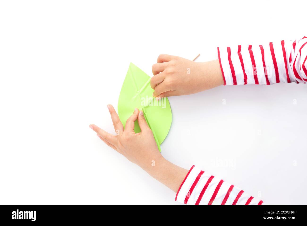 kids hands push strips on a green leaf shape paper detail, simple paper ...