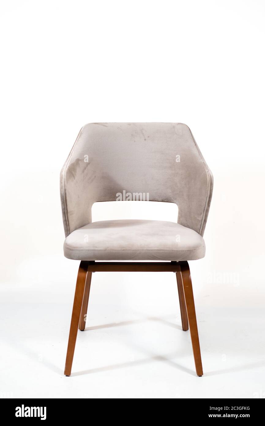 Vertical shot of a white chair with wooden legs behind a white ...