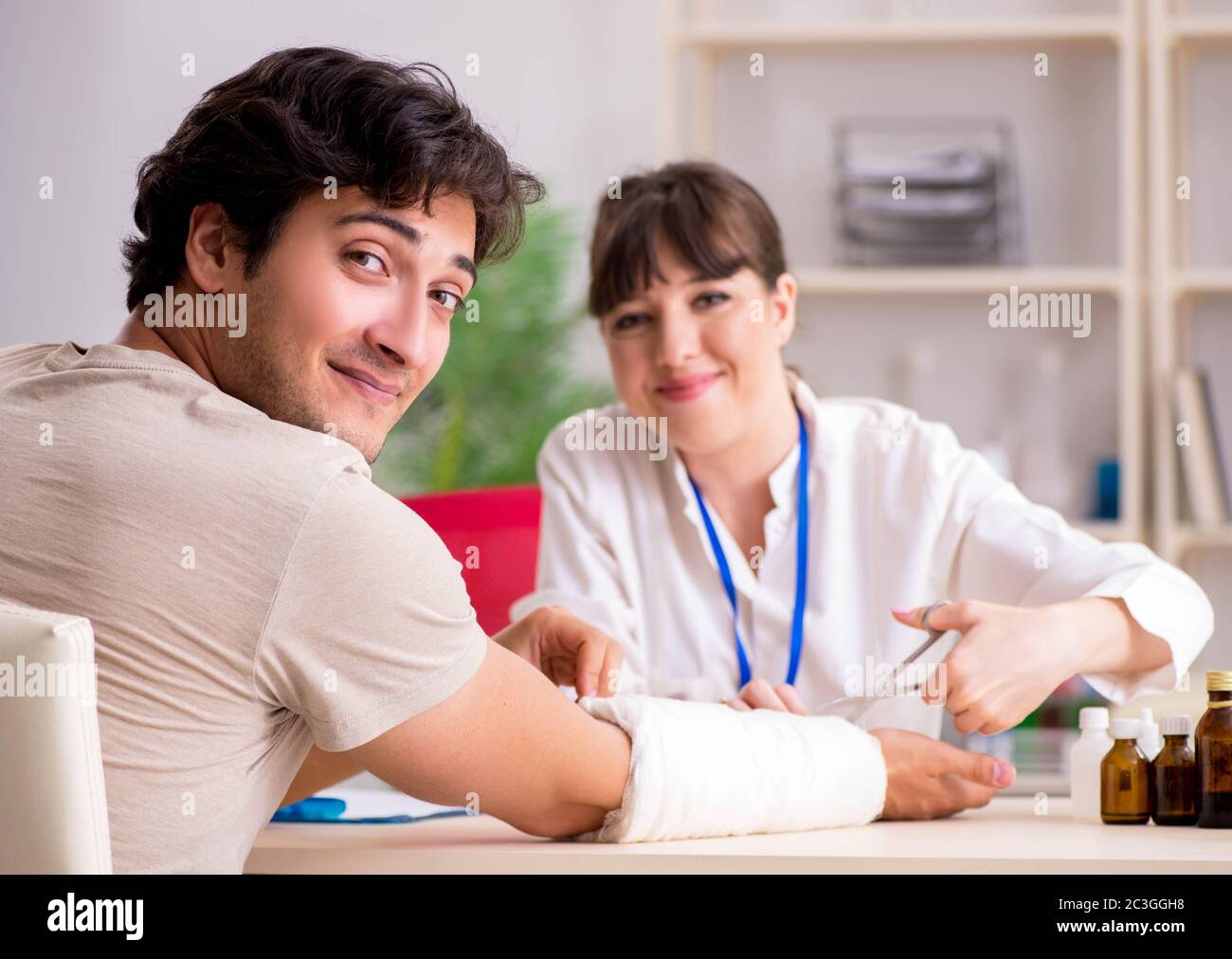 Young man with bandaged arm visiting female doctor traumatologis Stock ...
