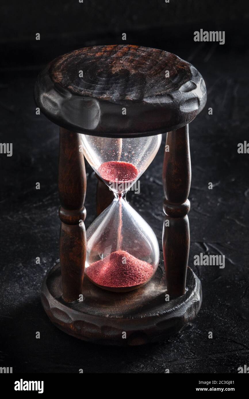 Time is running out concept. An hourglass with sand falling through, on ...