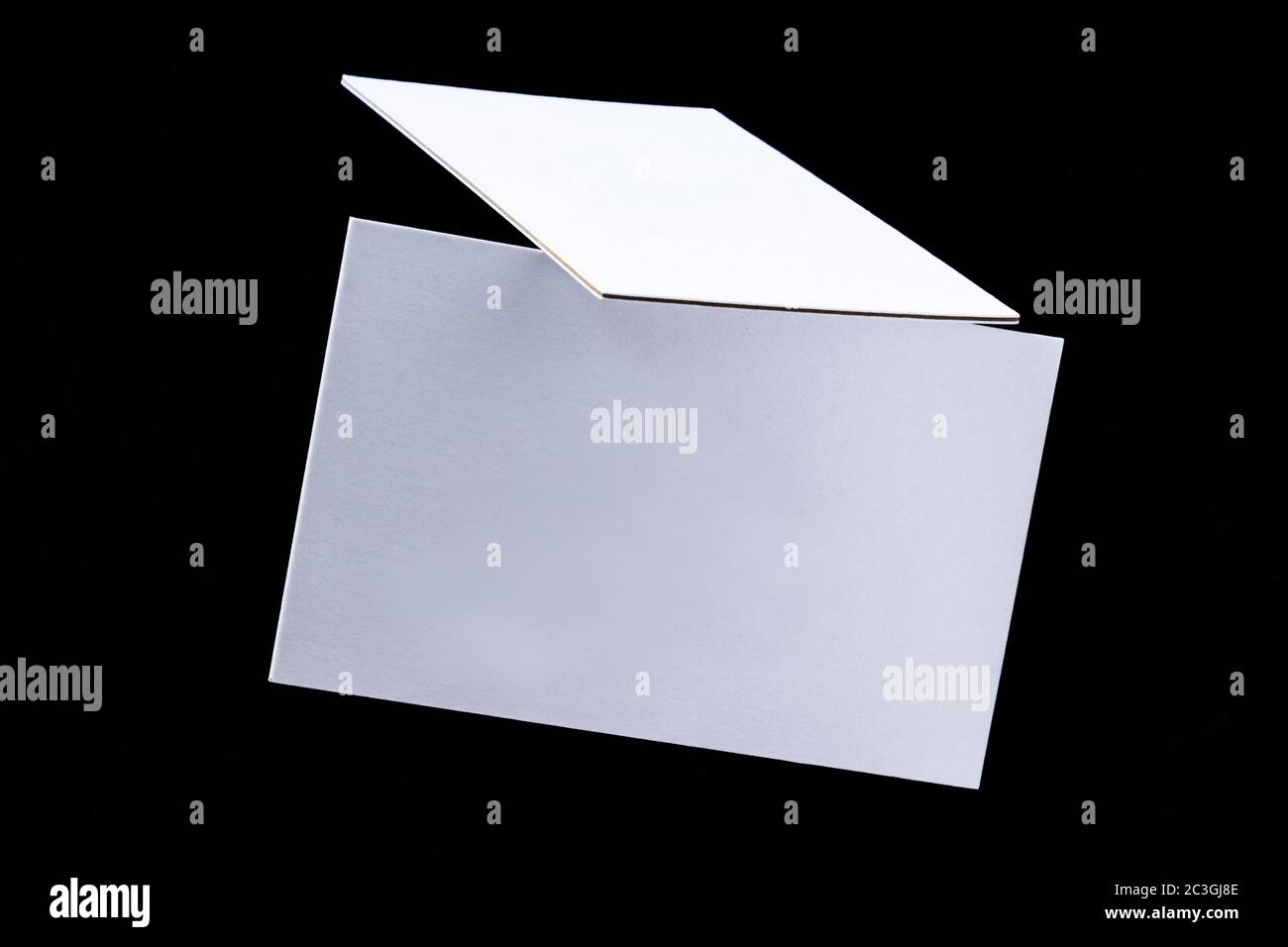 White triple business cards, floating on a black background, a mock-up ...
