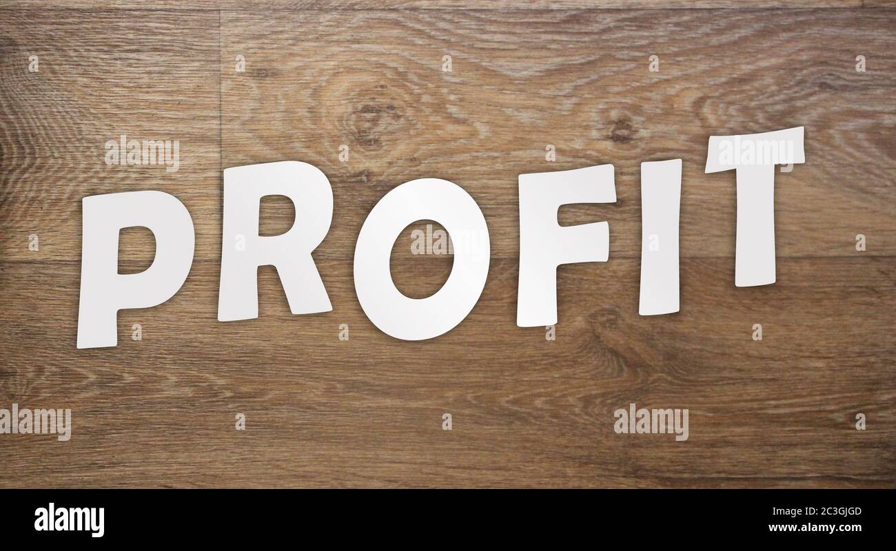 Profit text word letters cut from white paper on wooden background ...