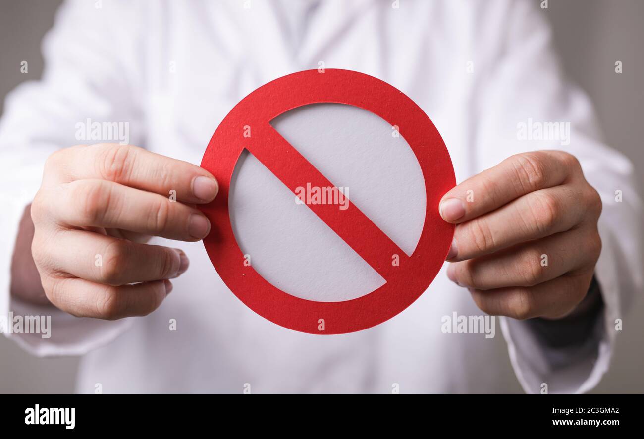 Man's hands and the red stop sign near Stock Photo - Alamy