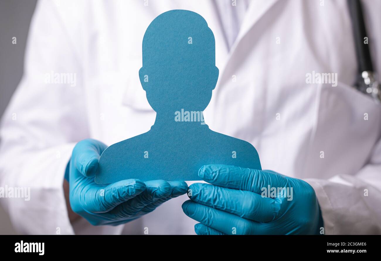 Papercut of a male figure in the hands of a doctor with medical gloves ...