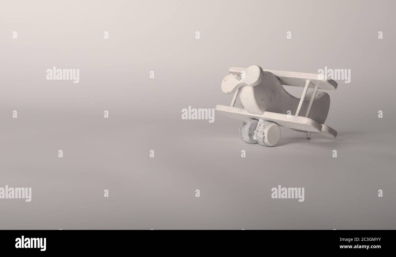 Small white biplane on the grey background Stock Photo - Alamy