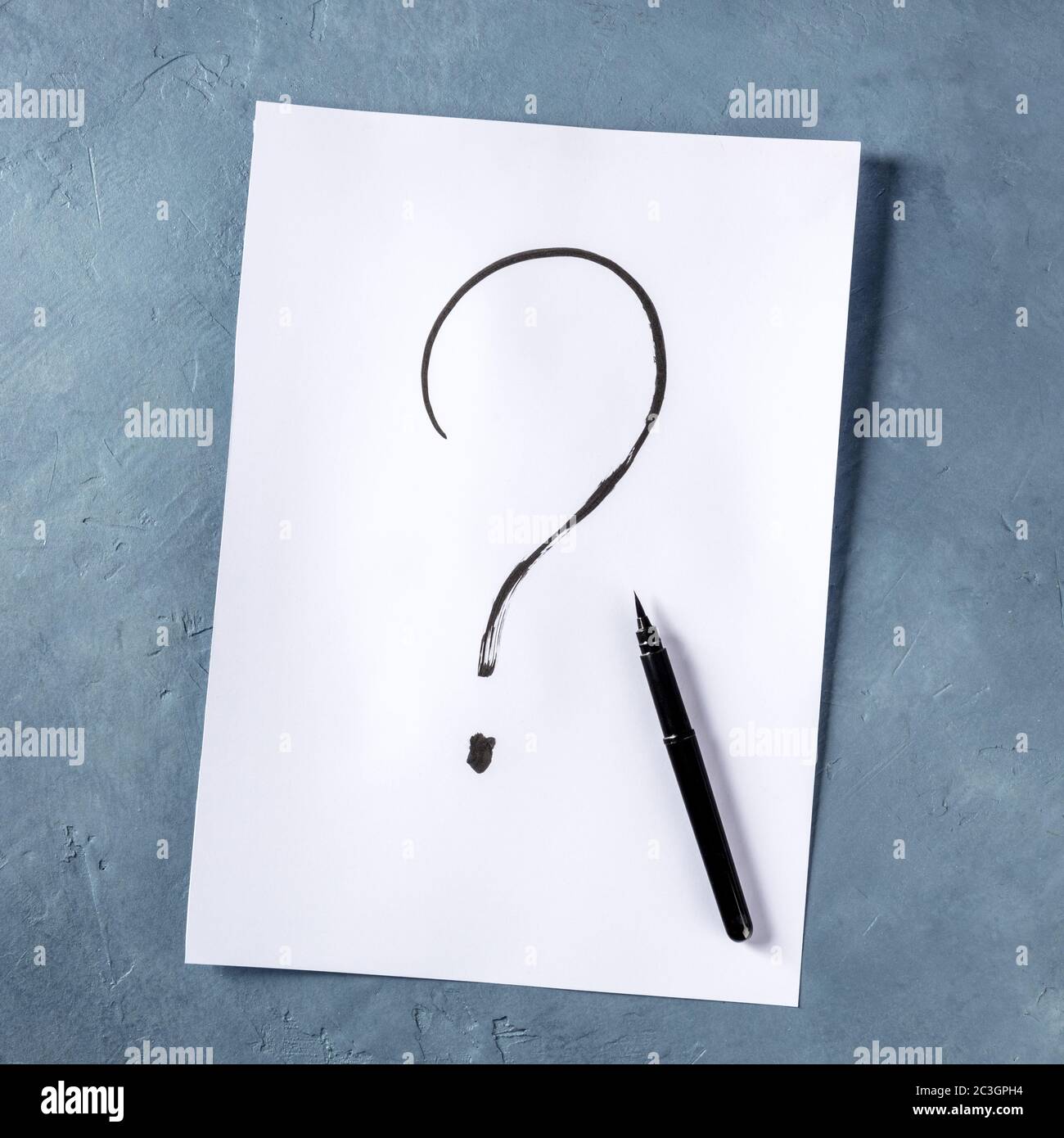 Question mark, written in ink on a piece of standard office paper ...