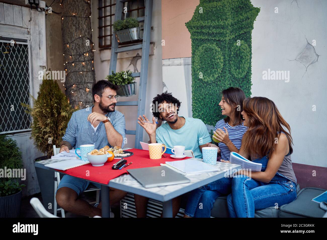Group of young students taking a break from study with coffee and ...