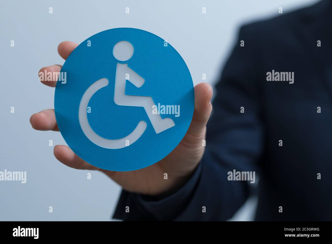 Man holding a circle sign with a disability symbol Stock Photo - Alamy