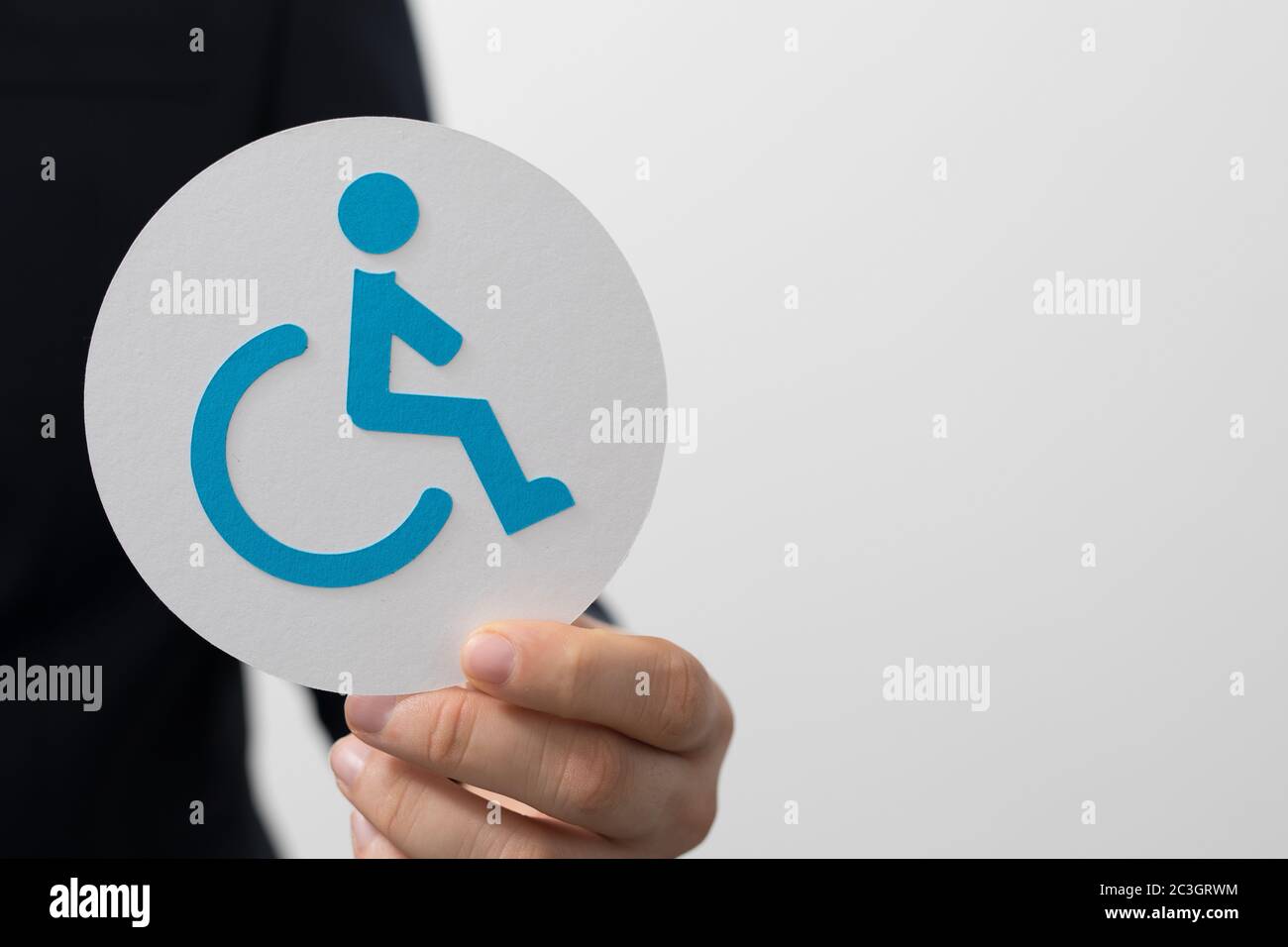 Man holding a circle sign with a disability symbol Stock Photo - Alamy