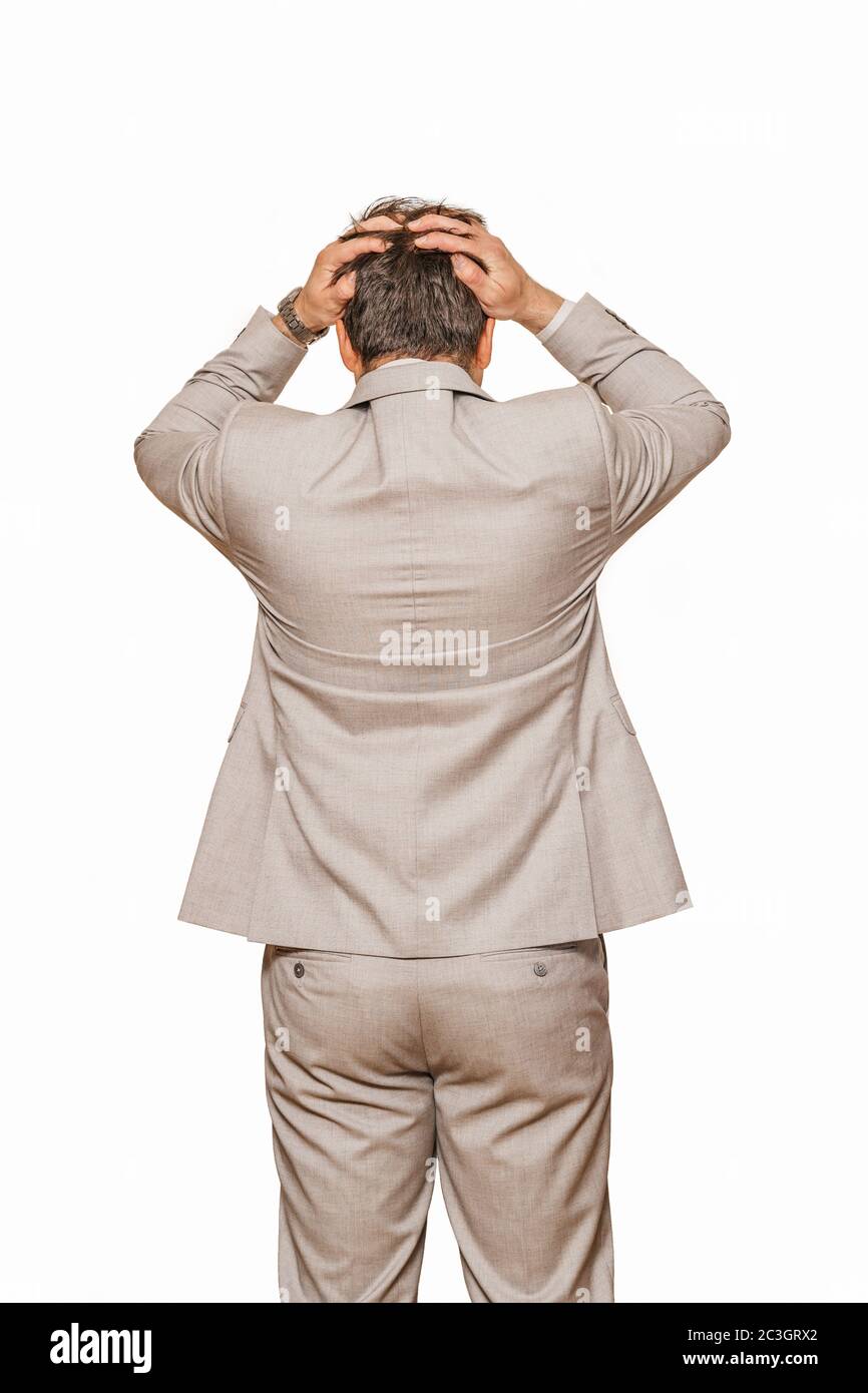 Back view of middle age businessman in beige suite pulling his hair out ...