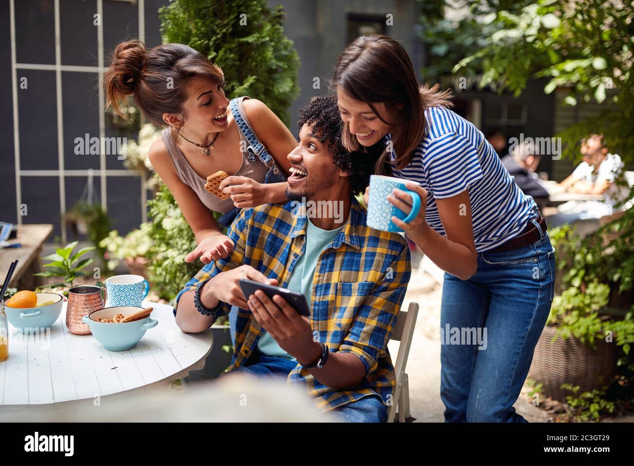 Friends laughing at funny content of mobile in relaxed atmosphere of ...