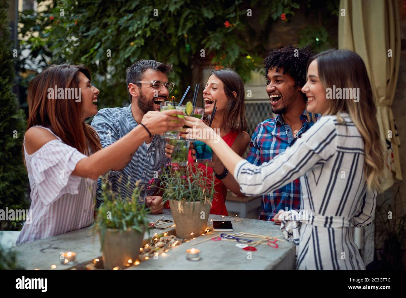 Group of cheerful friends making a toast at cafe's garden Stock Photo ...
