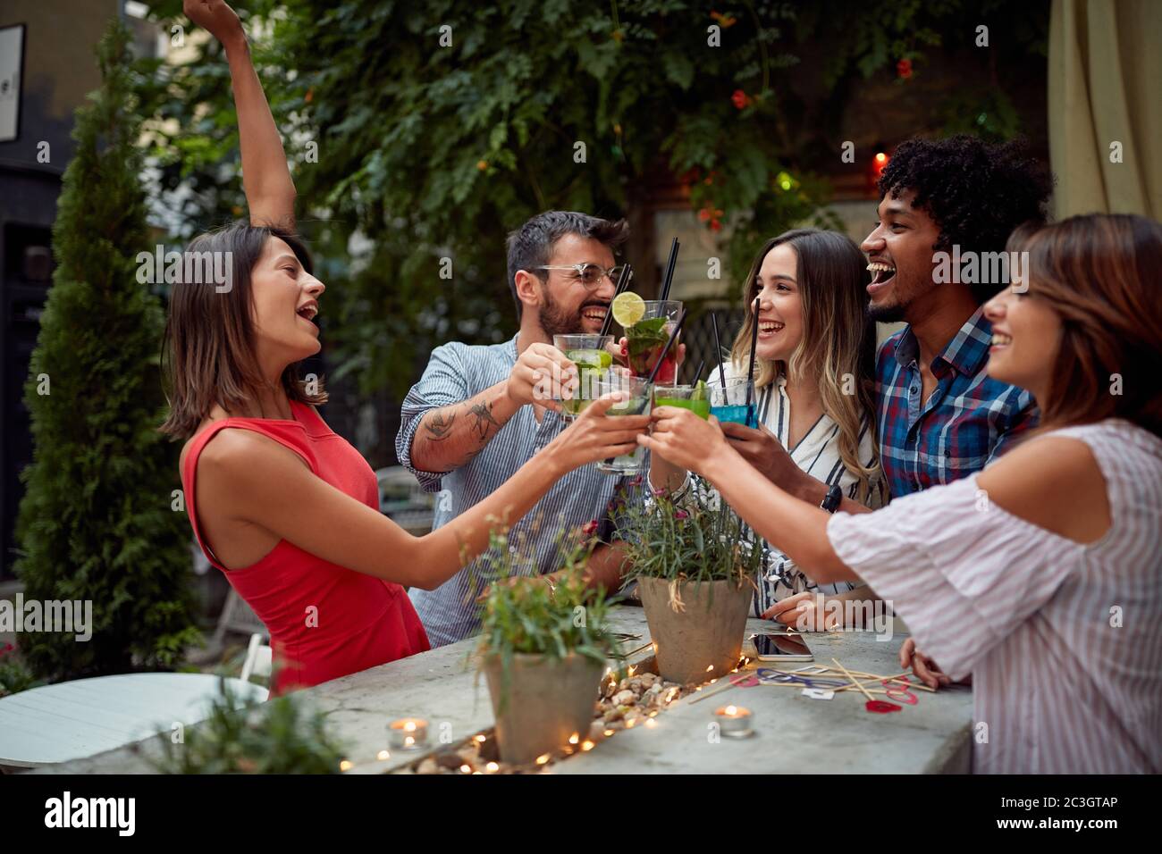 Group of young cheerful people make a toast at a party Stock Photo - Alamy