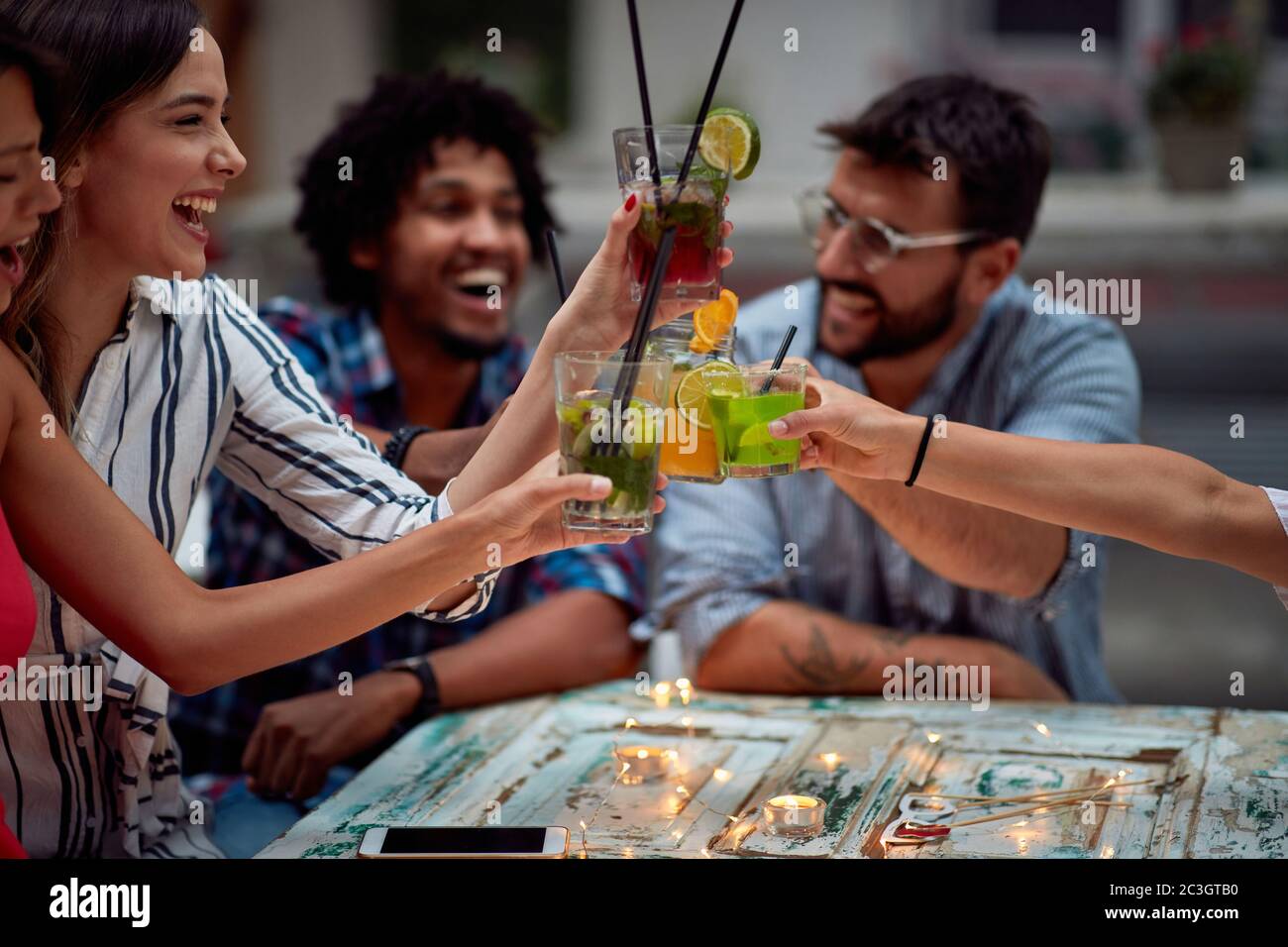 Group of young cheerful friends making a toast at night party Stock ...