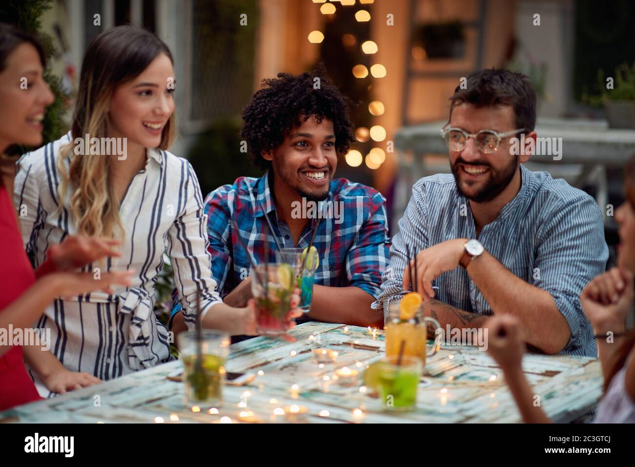 Group of friends having a drink together at party Stock Photo - Alamy