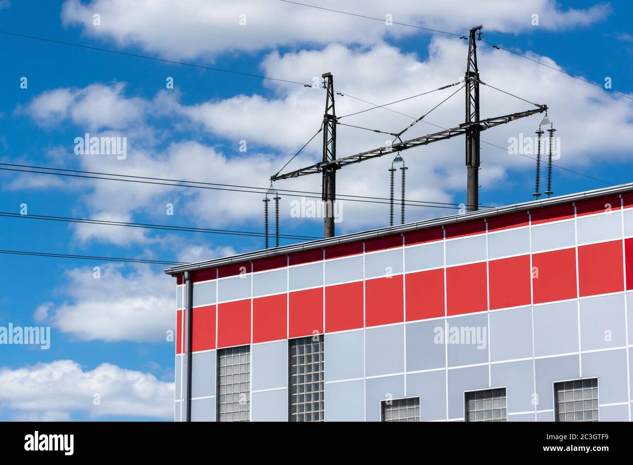 Red and white power station. into a clear blue sky with a high voltage ...