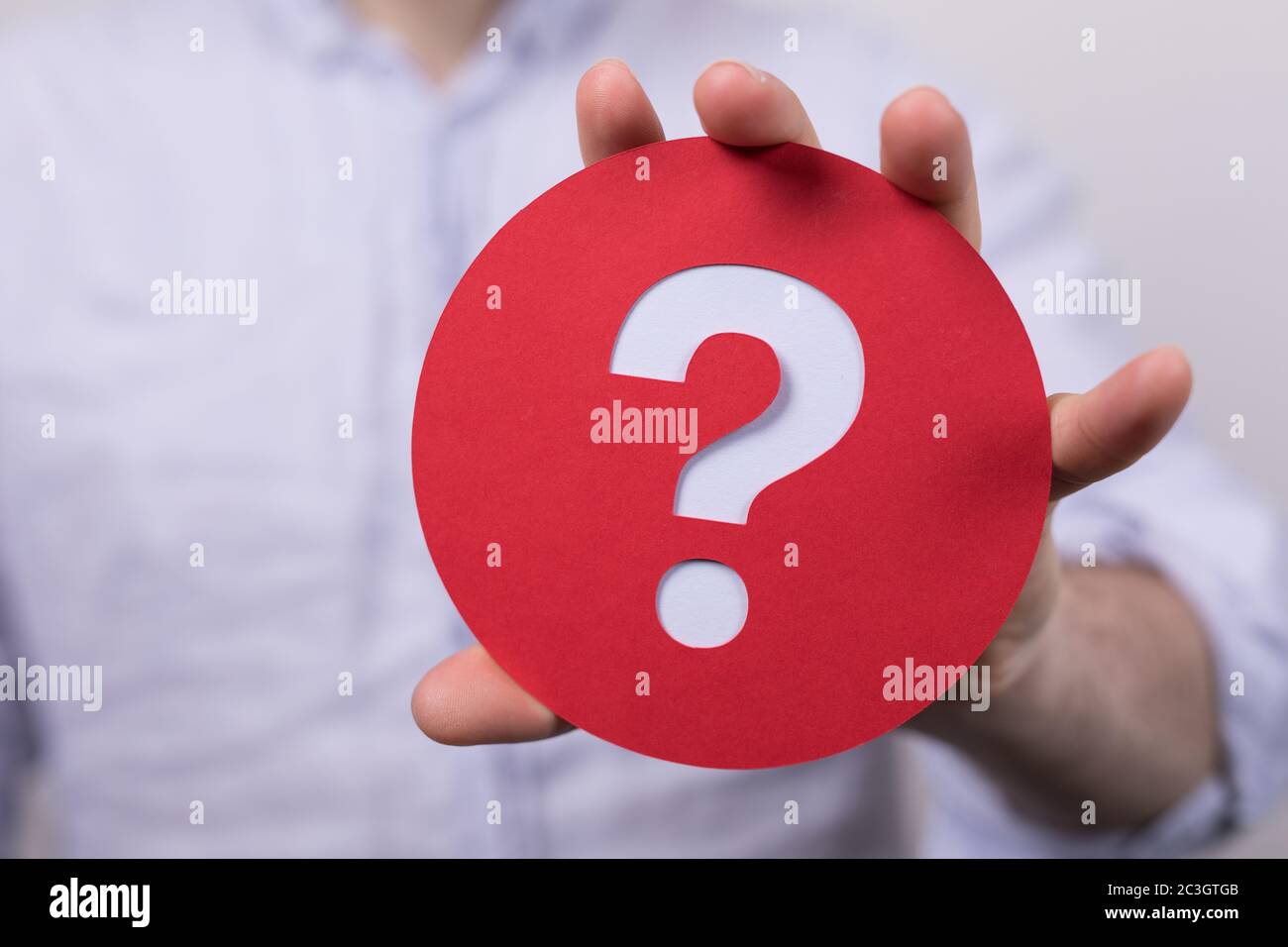 Man holding a round red sign with white question sign on it Stock Photo ...