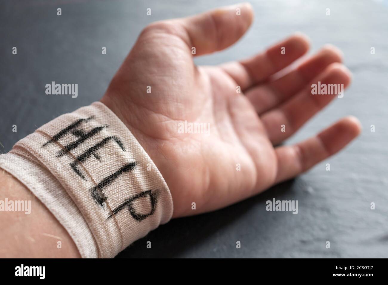 Forearm of a man with a bandage and the word help in English Stock ...