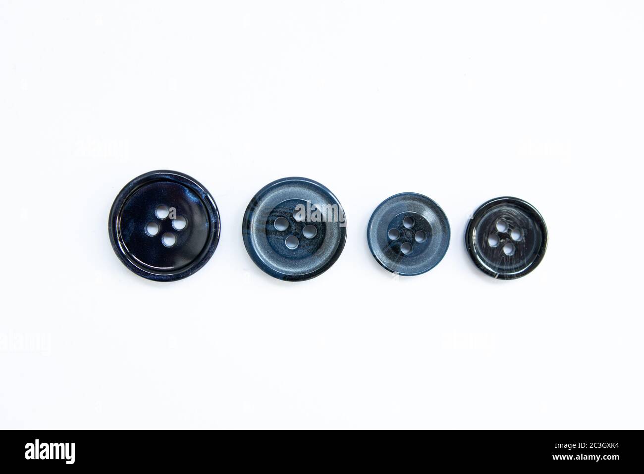 black buttons for clothes on white background Stock Photo - Alamy