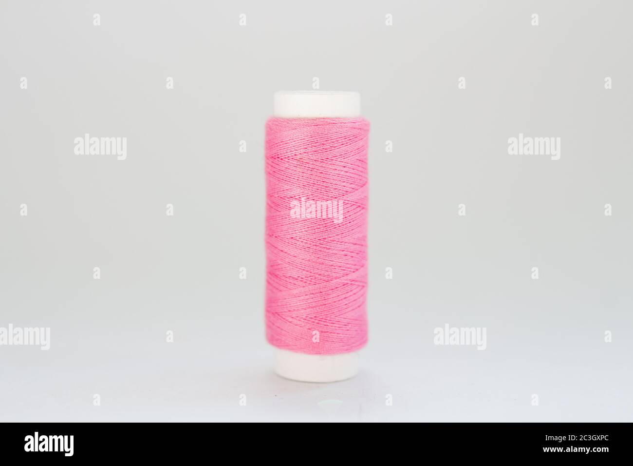 pink threads on white background Stock Photo - Alamy