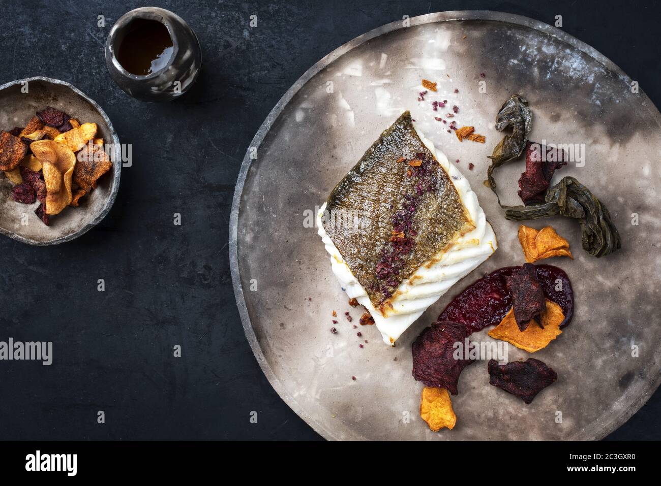 Gourmet fried European skrei cod fish filet with algae and vegetable ...