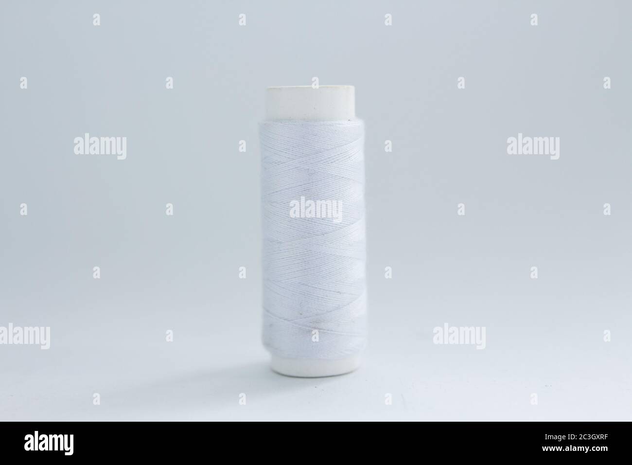 spool of white thread on white background Stock Photo - Alamy