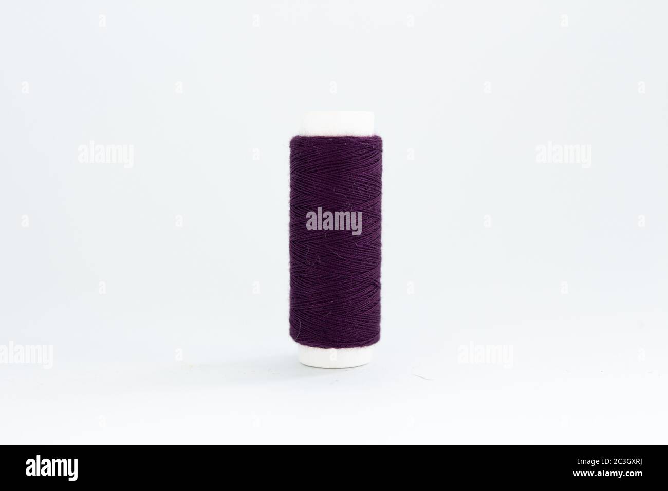 spool of black thread on white background Stock Photo - Alamy