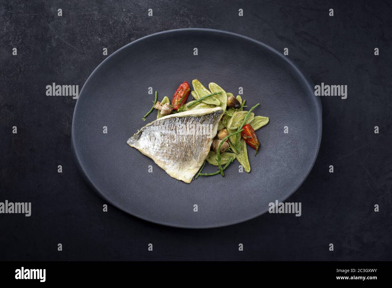 Gourmet fried Italian gilthead fish filet with spinach pasta Stock ...